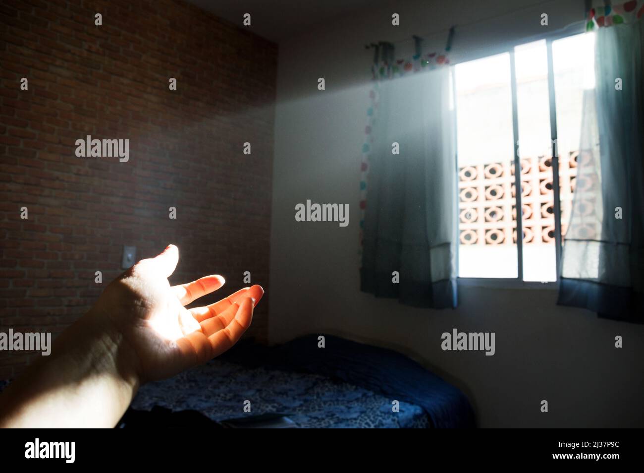 Outstretched woman's hand receiving rays of the sun that are entering ...