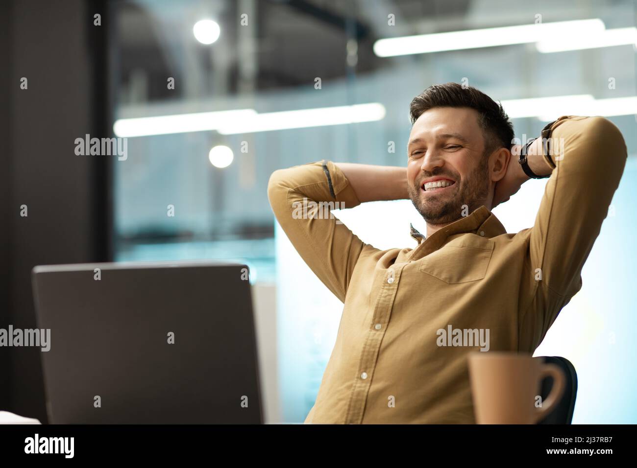 Happy Businessman Looking At Laptop Computer Relaxing Sitting In Office ...
