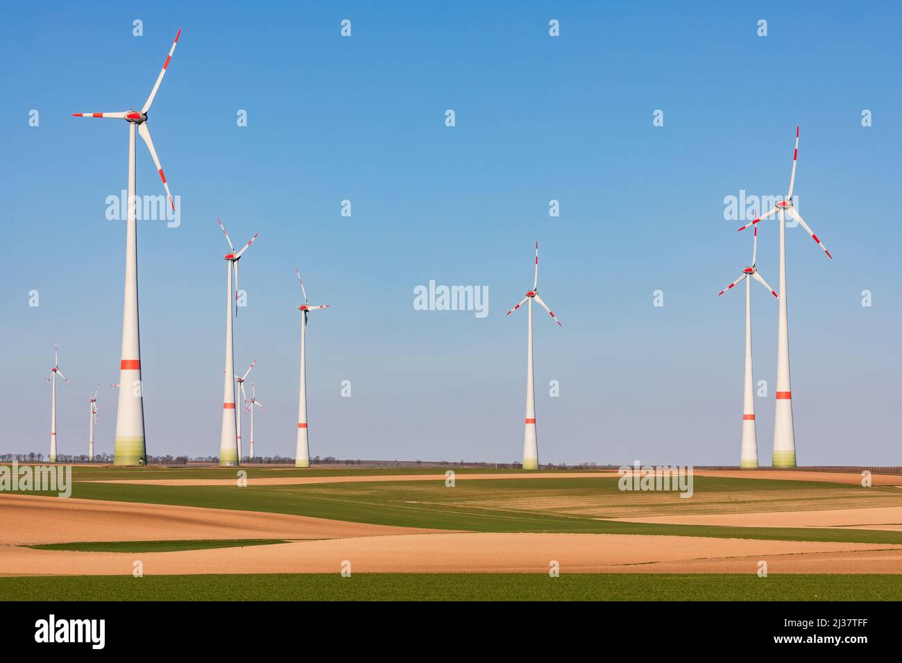 Massive towers of a wind farm dominate a rural landscape in Germany ...