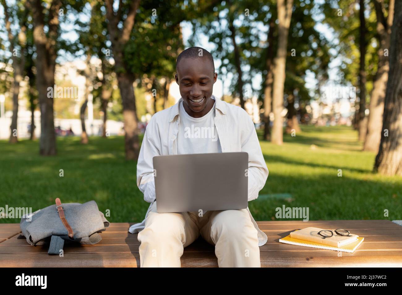 Positive african american student guy with laptop learning online and ...