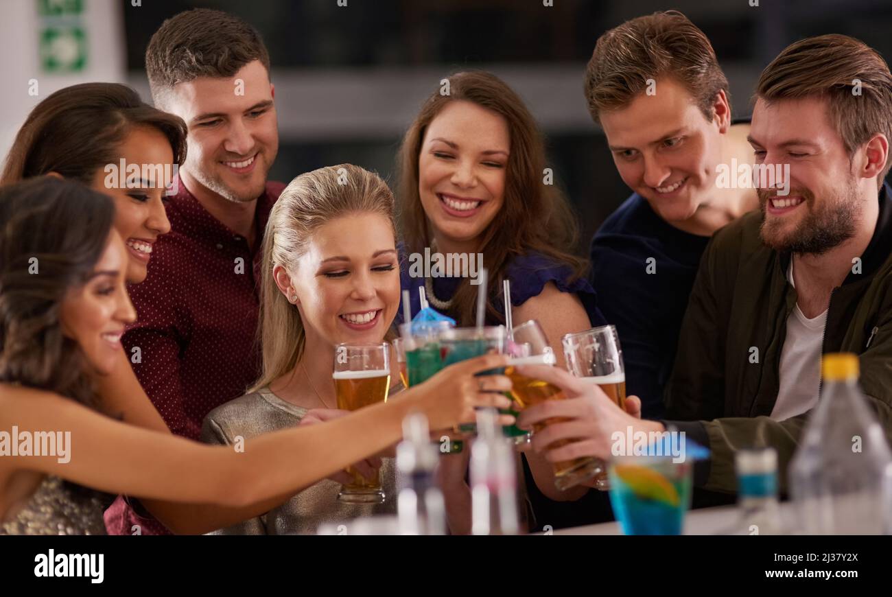 Cheers to Friday night. Shot of a happy group of friends having drinks ...