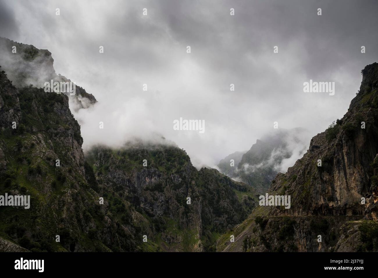 Sharp cliffs of limestone and deep gorges under the clouds in a grey ...