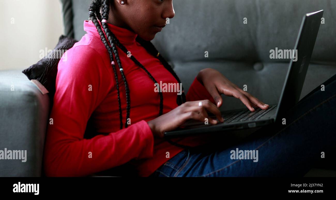 African adolescent girl doing homework in front of laptop screen Stock ...