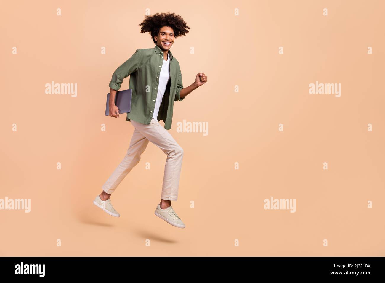 Full length body size view of attractive cheery guy jumping holding ...