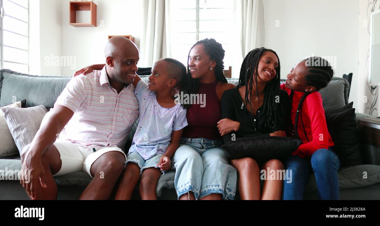 Beautiful Black African family sitting at couch smiling at camera, parents and children Stock ...