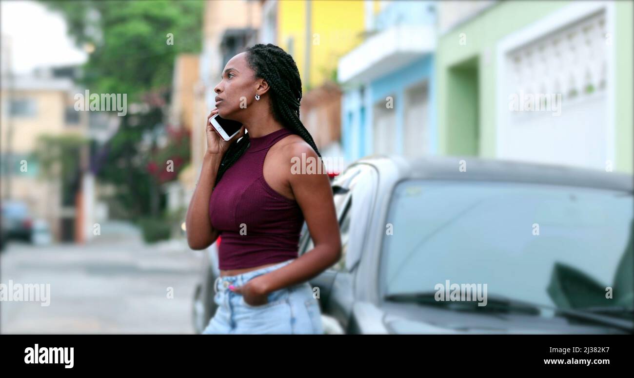 Black African woman talking on phone outside, candid mix race lady ...