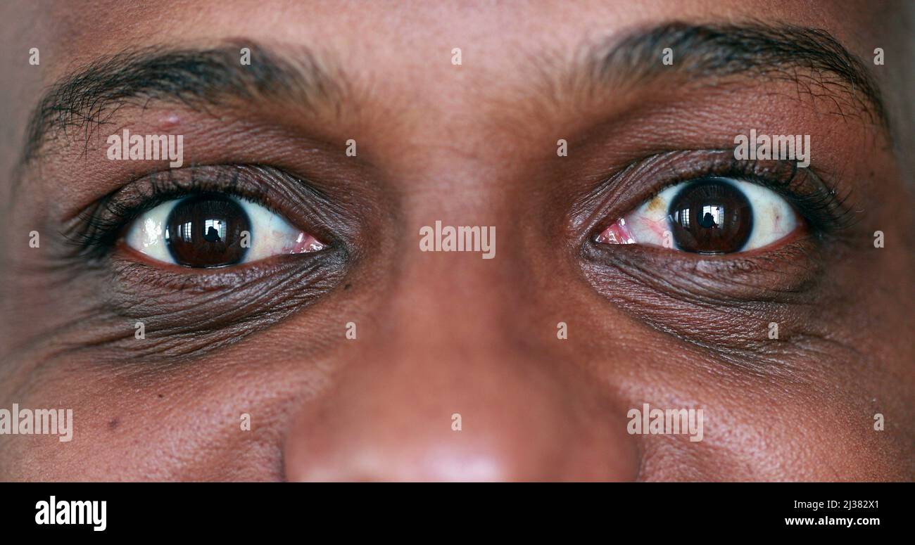 Extreme face close-up, macro eyes of black African man looking sideways ...