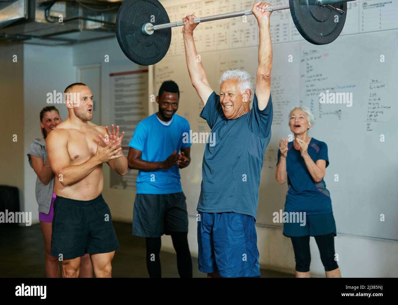 Impossible is nothing. Shot of a senior man lifting weights while a ...