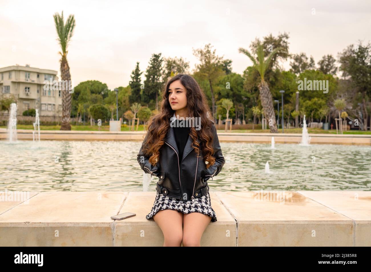 Young woman in a stressful wait, she is depressed and sitting by a pool ...
