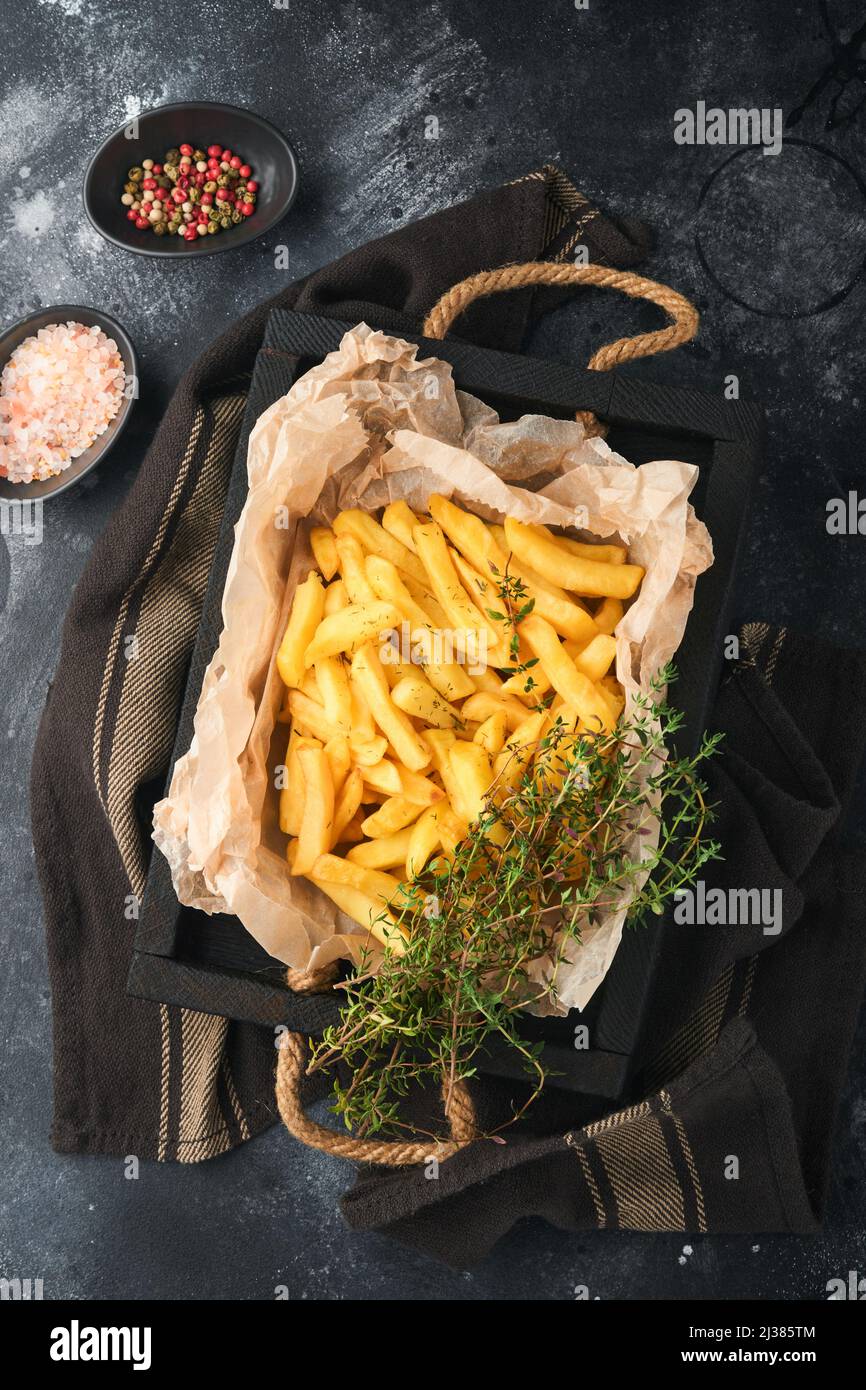 French fries. Tasty French fries server on parchment paper on wooden ...