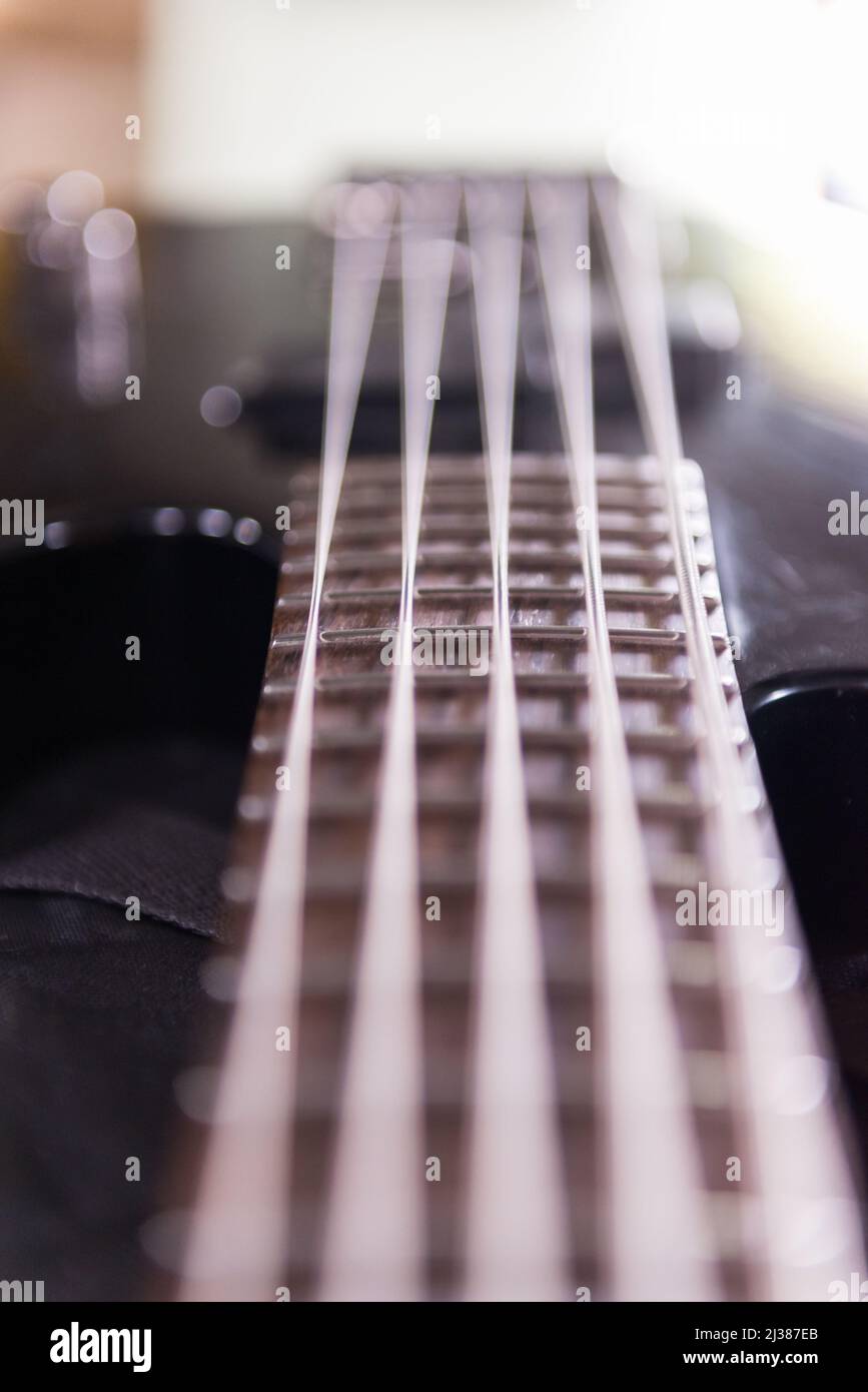 A vertical shot of the neck of a black acoustic guitar with five ...