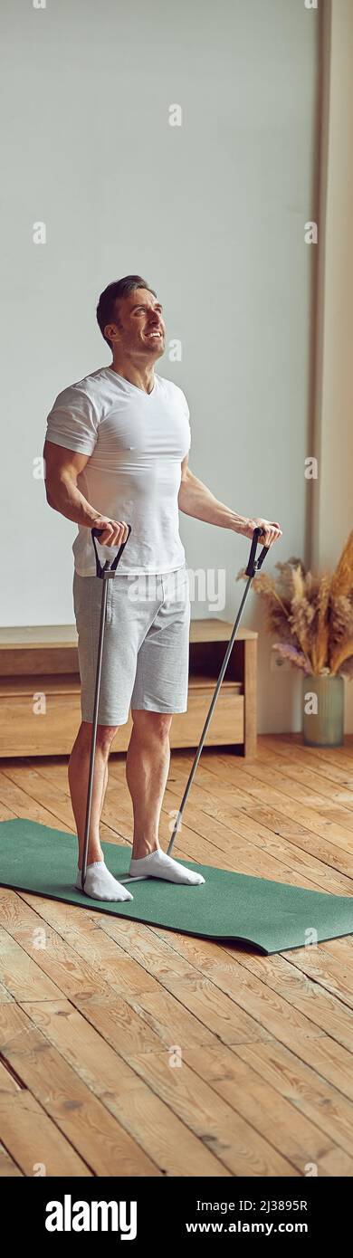 Strong man using resistance bands at home Stock Photo - Alamy