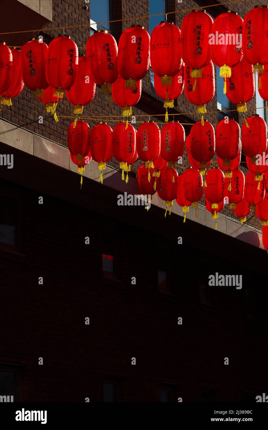 Red lanterns are backlit by the sun as people stroll in Chinatown ...