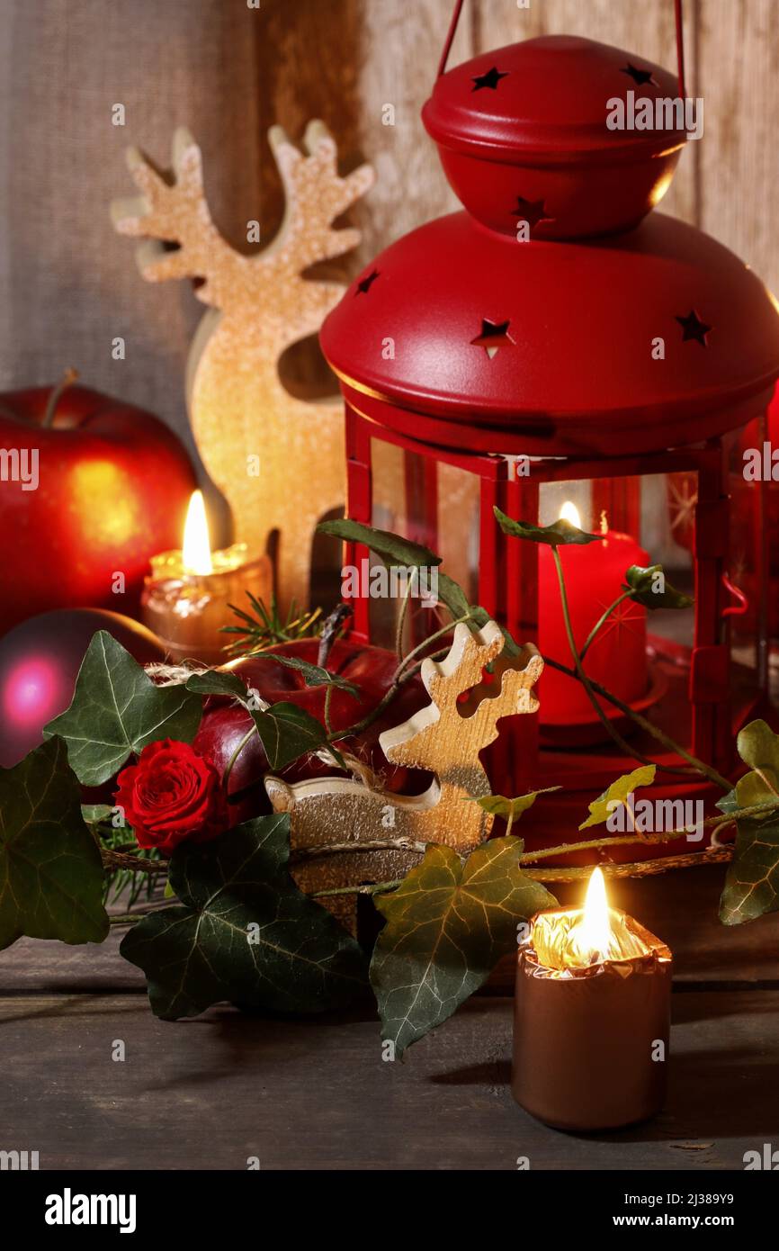Christmas decoration with red lantern, candle, apples and ivy leaves ...
