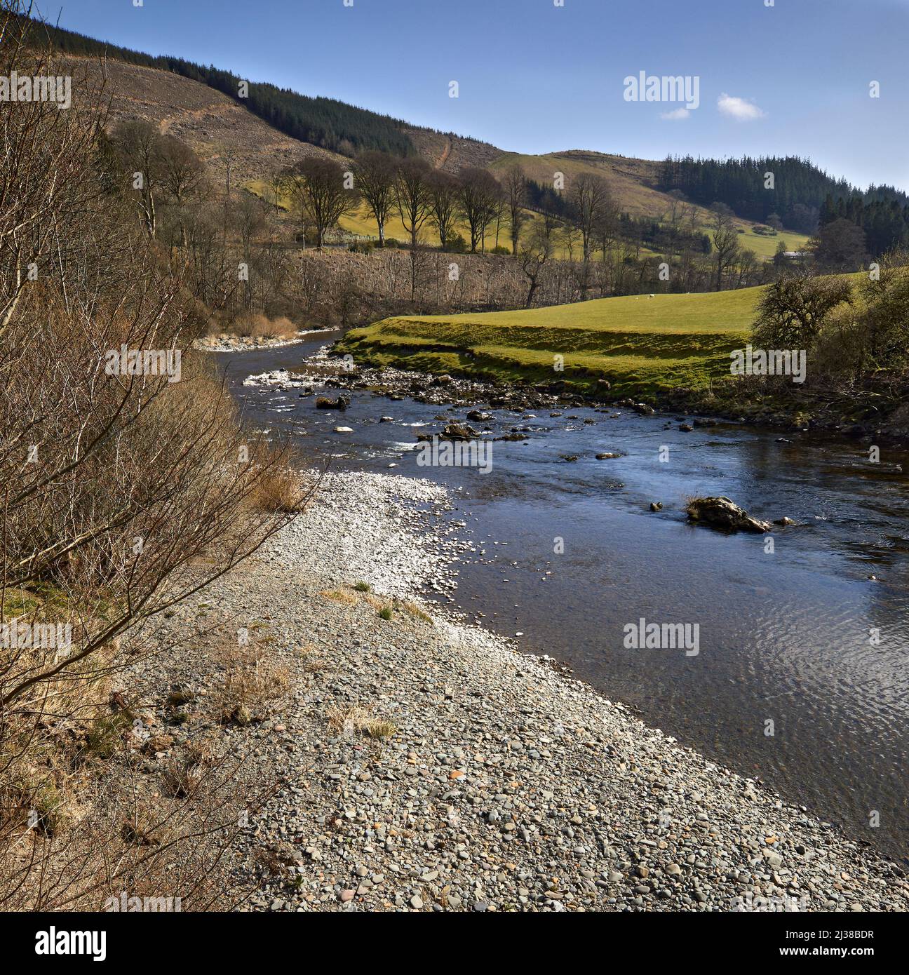 A sunny view downstream of the River Esk from the bridge at Bentpath ...
