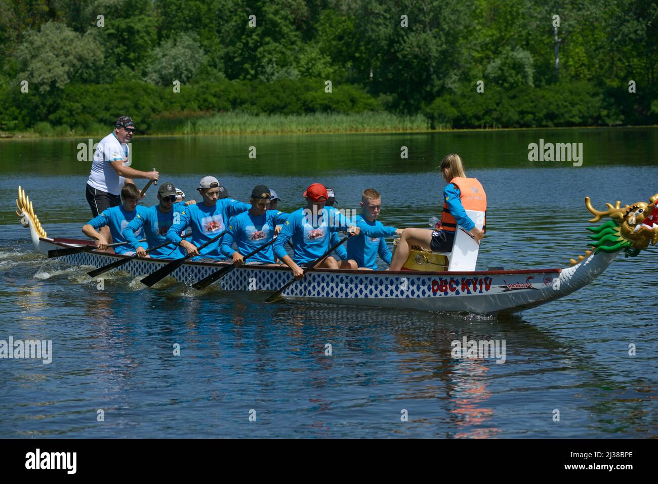 Oarsmen rowing a dragon boat on a river. Kiev oblast championship among ...