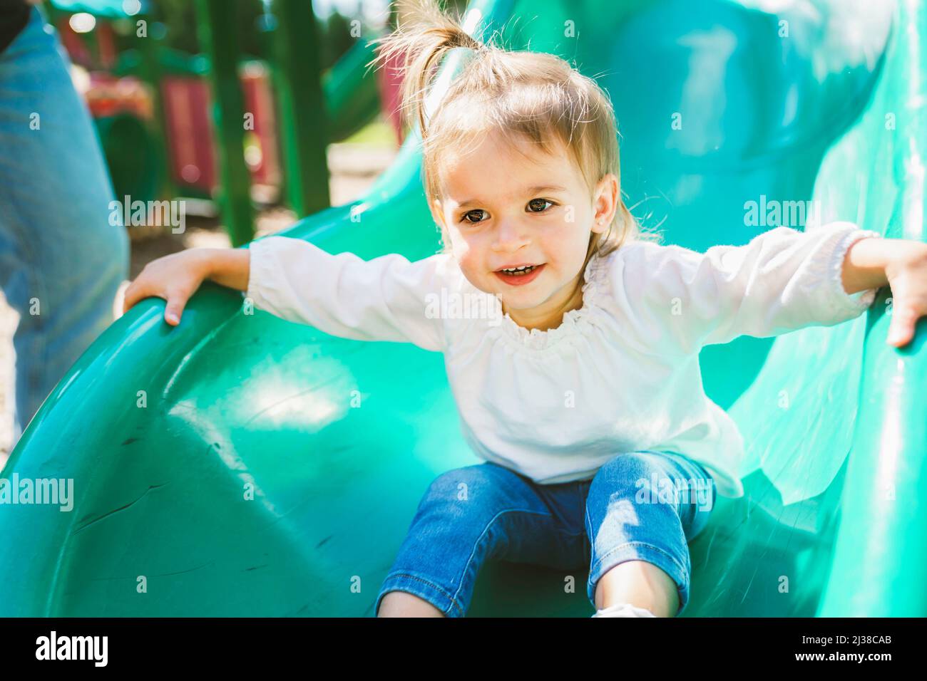 two years old girl in playground equipment play on slide Stock Photo ...