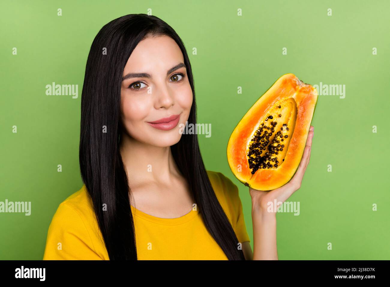 Portrait of adorable friendly girl hold demonstrate half papaya look ...