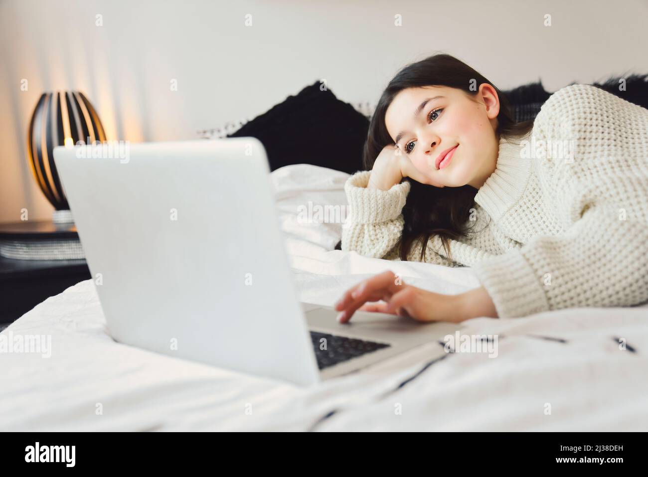 Nice teenage girl using a computer in her bedroom Stock Photo - Alamy