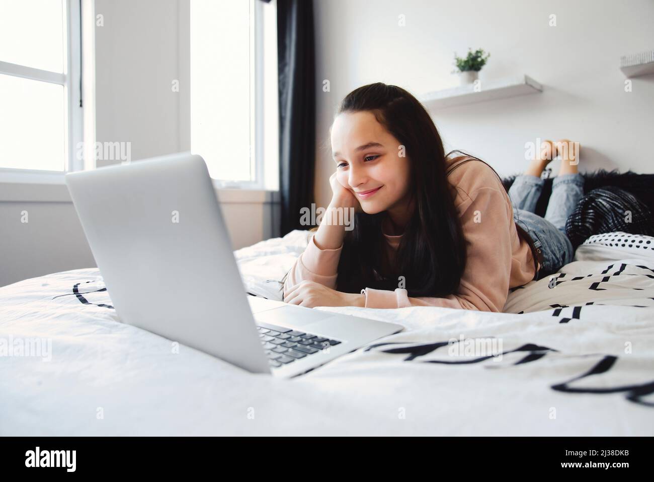 Nice teenage girl using a computer in her bedroom Stock Photo - Alamy