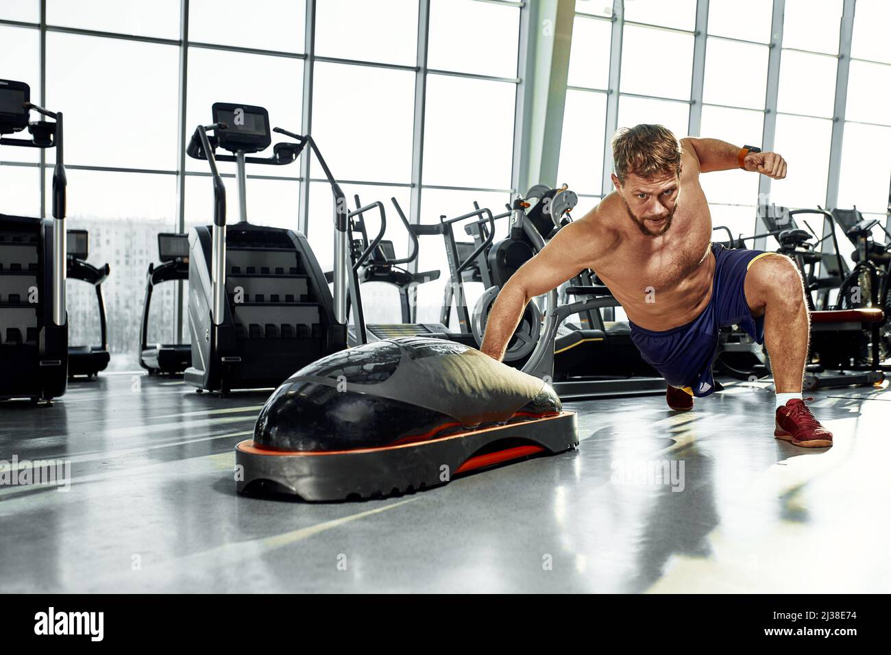 Handsome muscular men works out on functional training soft platform in ...