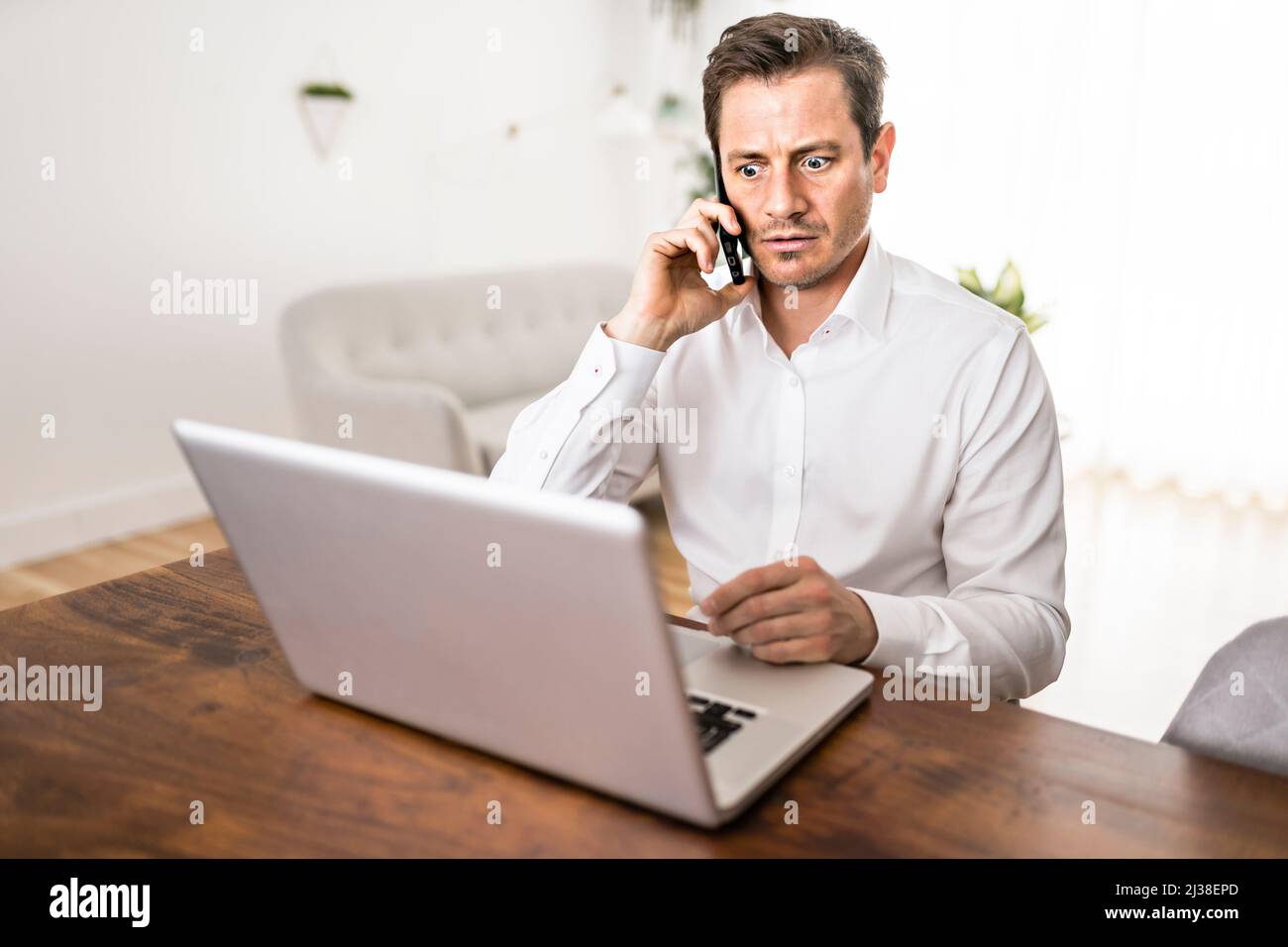 surprised business man working on laptop online sitting at kitchen ...