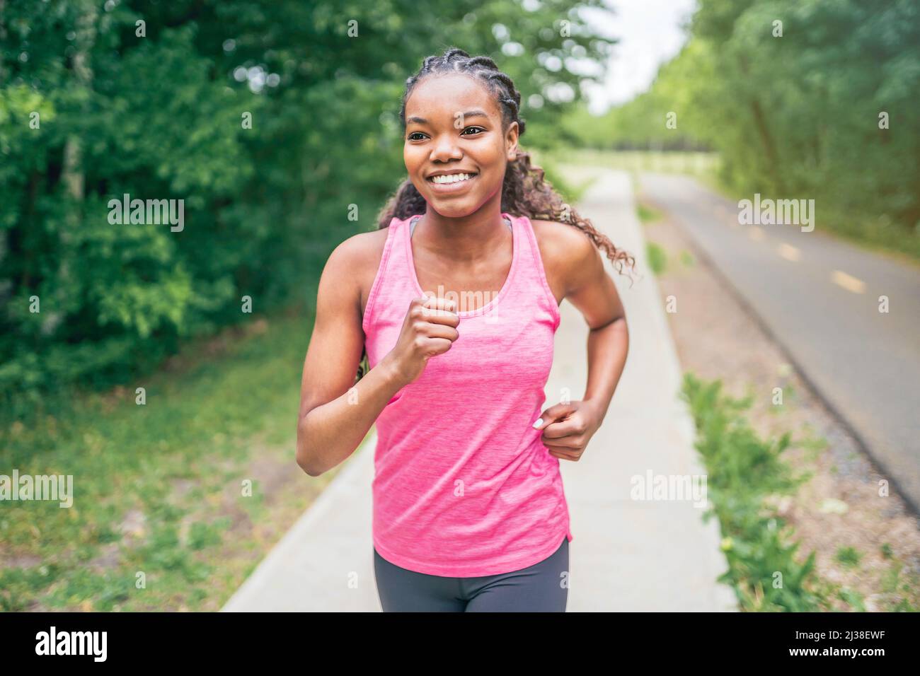 Woman runner in action outside in tree background Stock Photo - Alamy