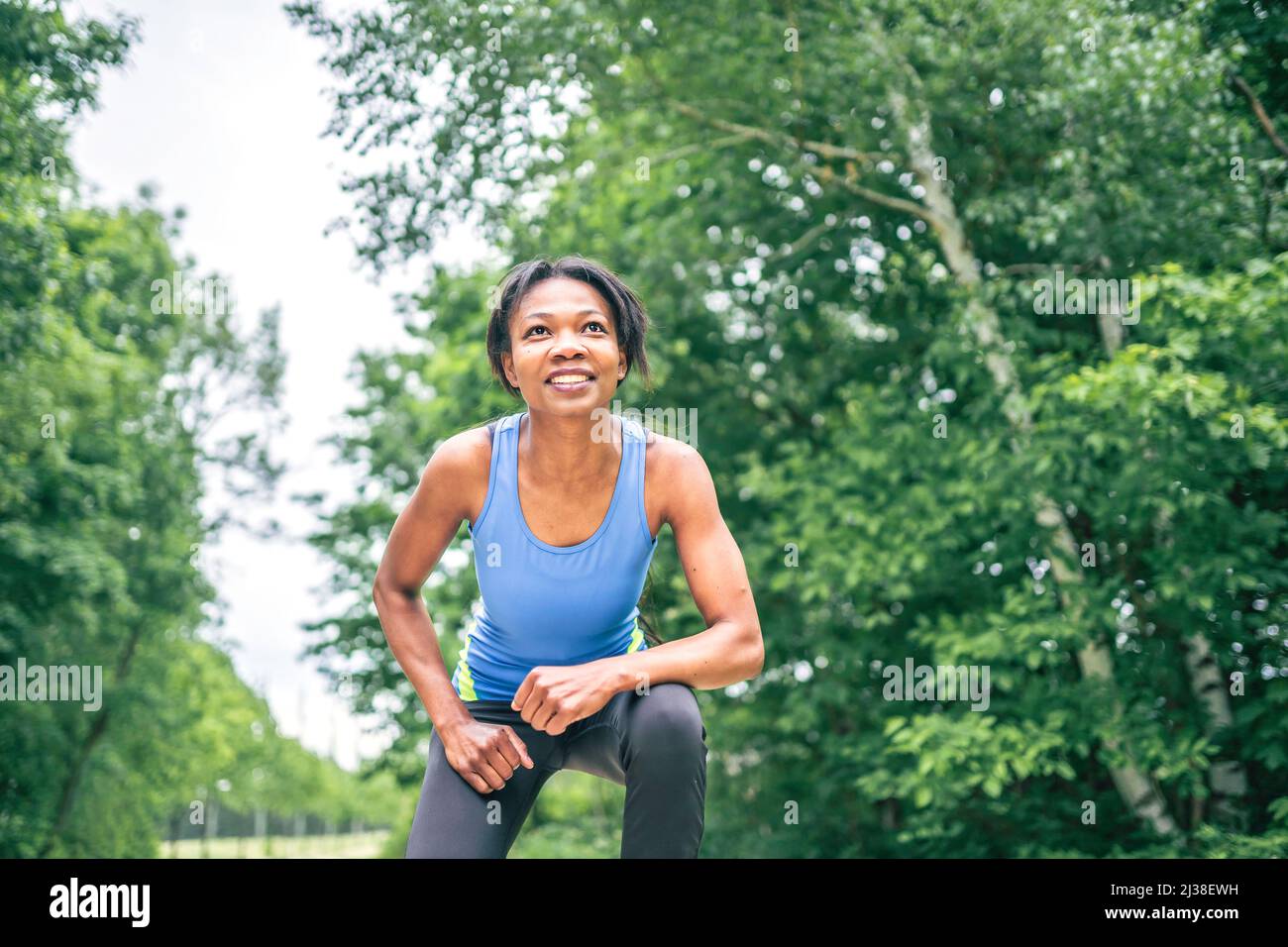 Woman runner in action outside in tree background Stock Photo - Alamy