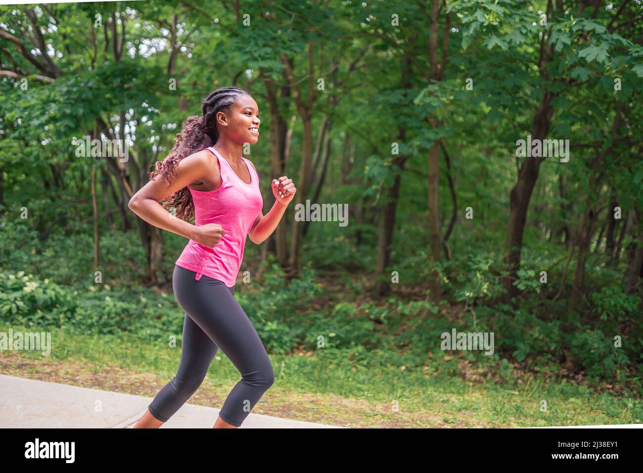 Woman runner in action outside in tree background Stock Photo - Alamy