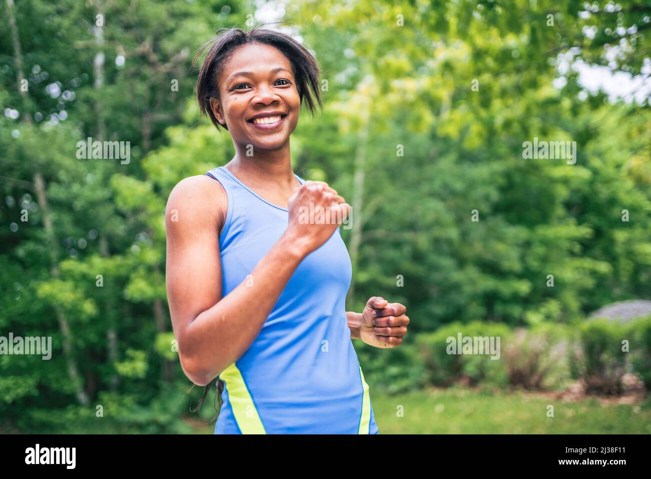 Woman runner in action outside in tree background Stock Photo - Alamy