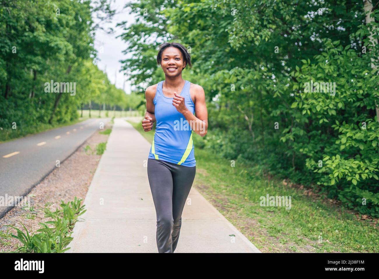 Woman runner in action outside in tree background Stock Photo - Alamy