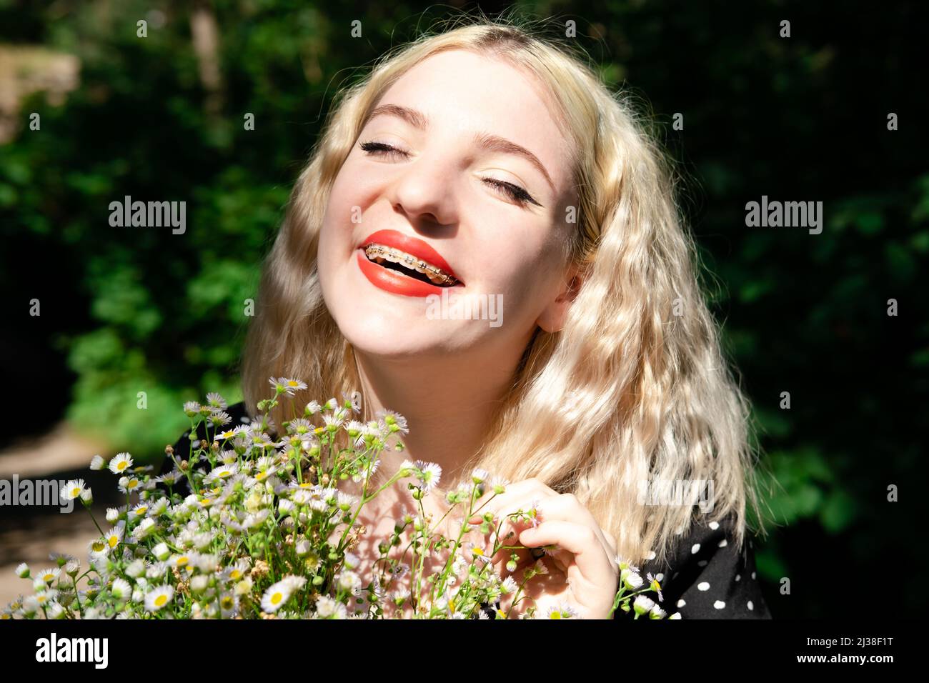 portrait of a charming blonde teenage girl wearing teeth braces with ...