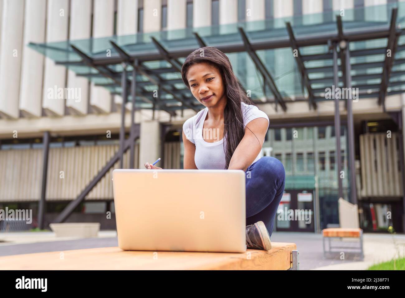 A black adult woman university student on campus with backpack Stock ...