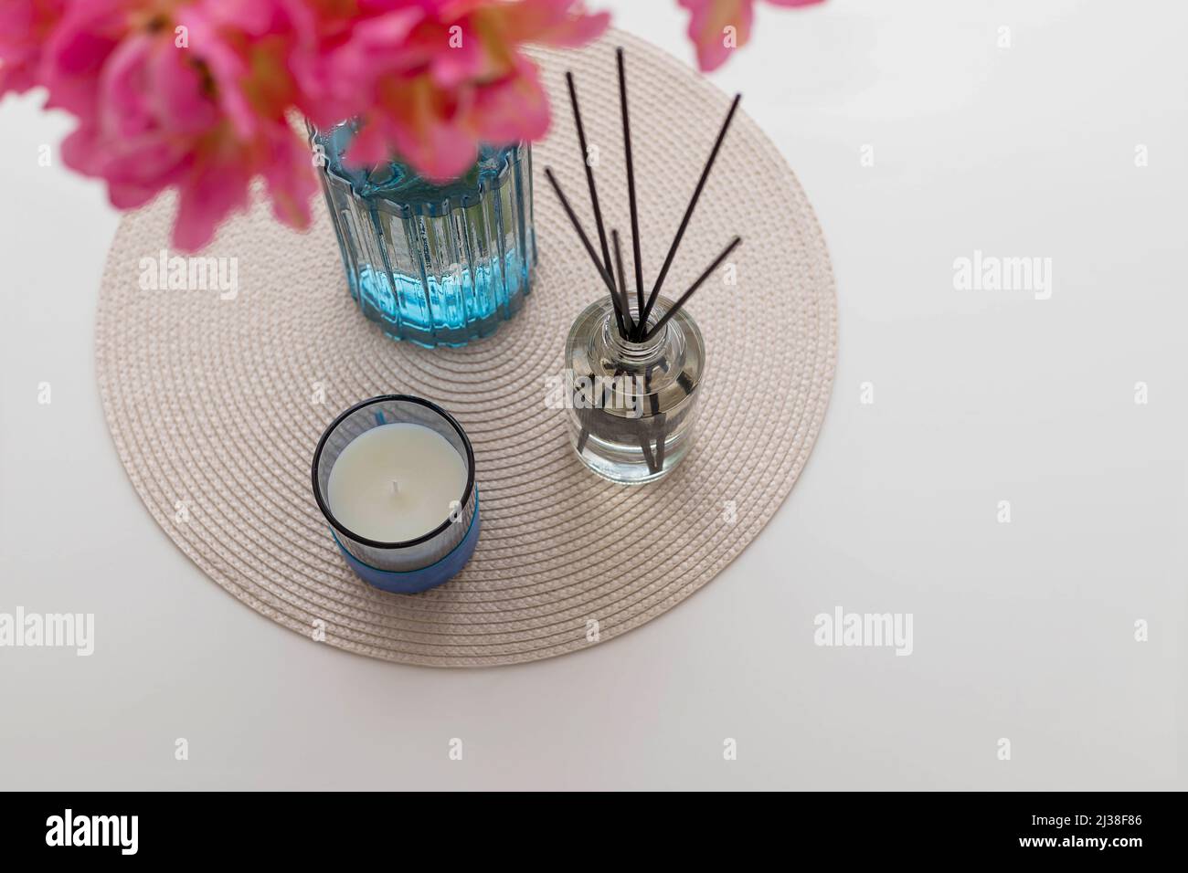 aroma reed diffuser, flower vase and candle on white table Stock Photo ...