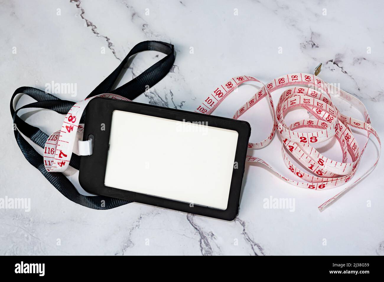 Black name tag with measure tap on white desk. Healthy and diet concept ...