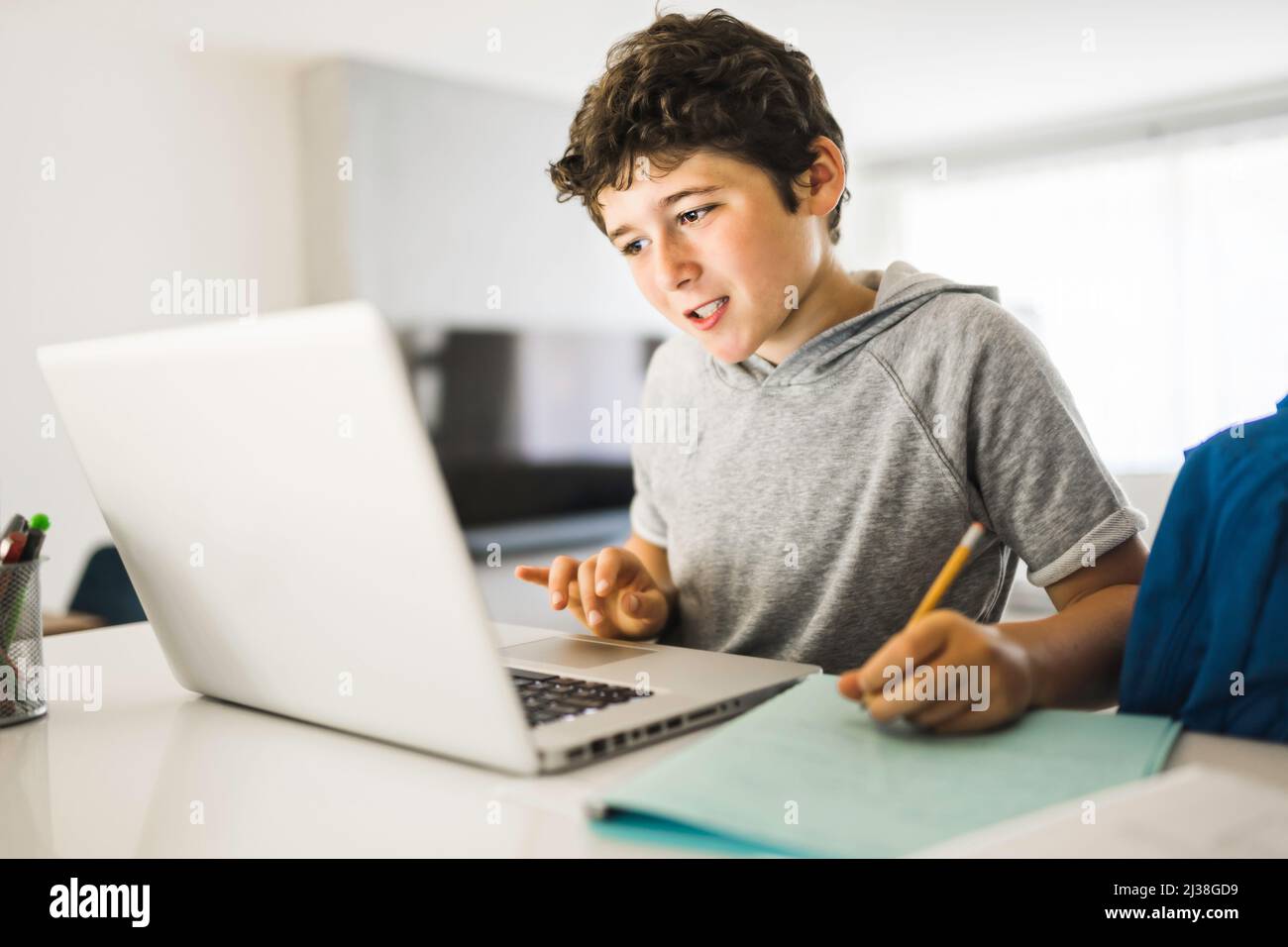 Pretty teen boy enjoys learning and doing some homework Stock Photo - Alamy