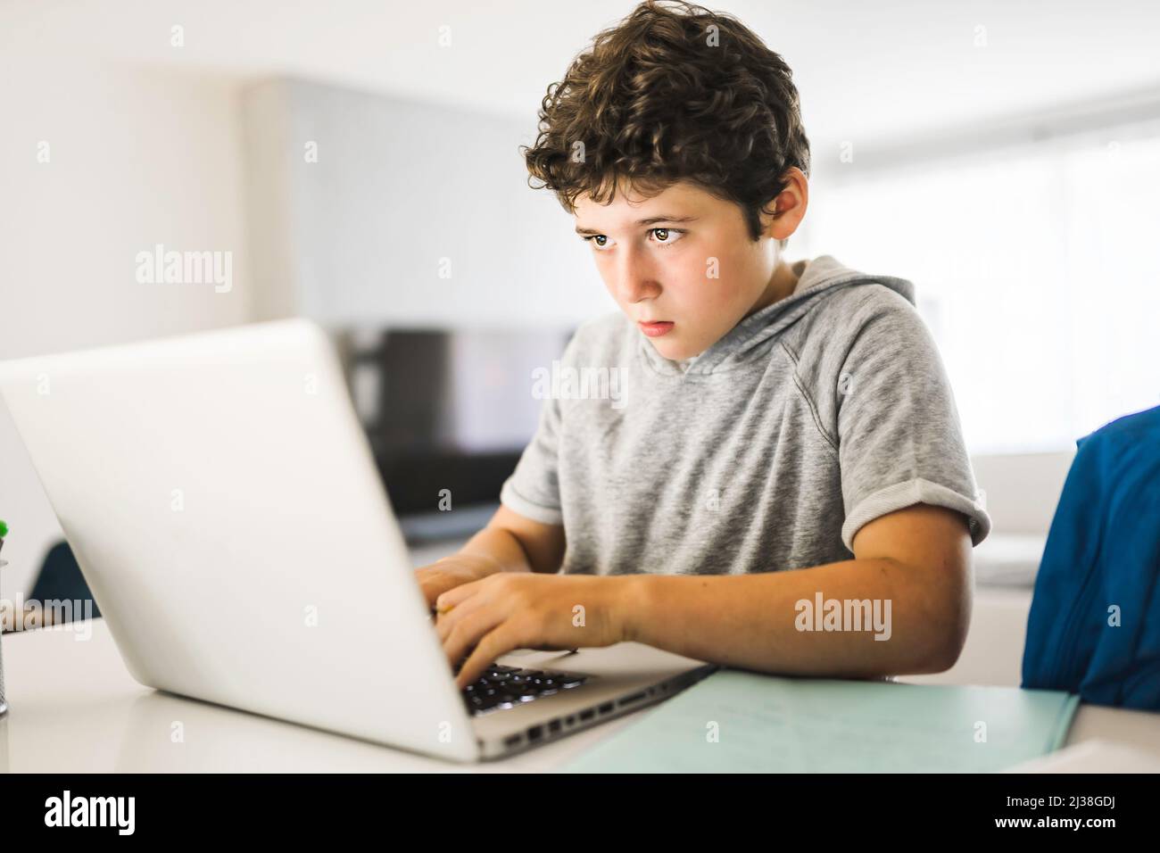 Pretty teen boy enjoys learning and doing some homework Stock Photo - Alamy