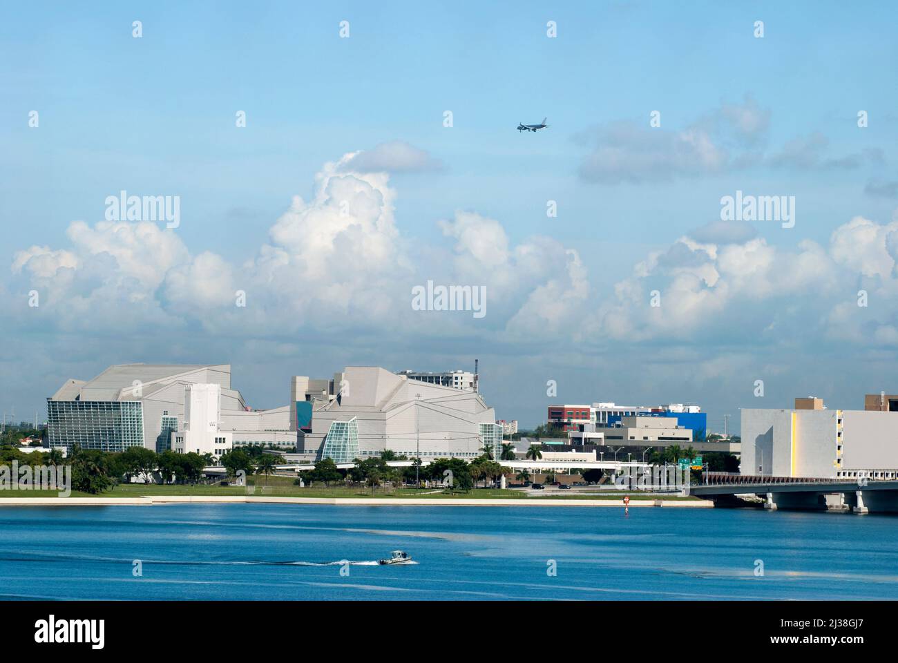 The view of an airplane flying over Miami and a motorboat passing by ...
