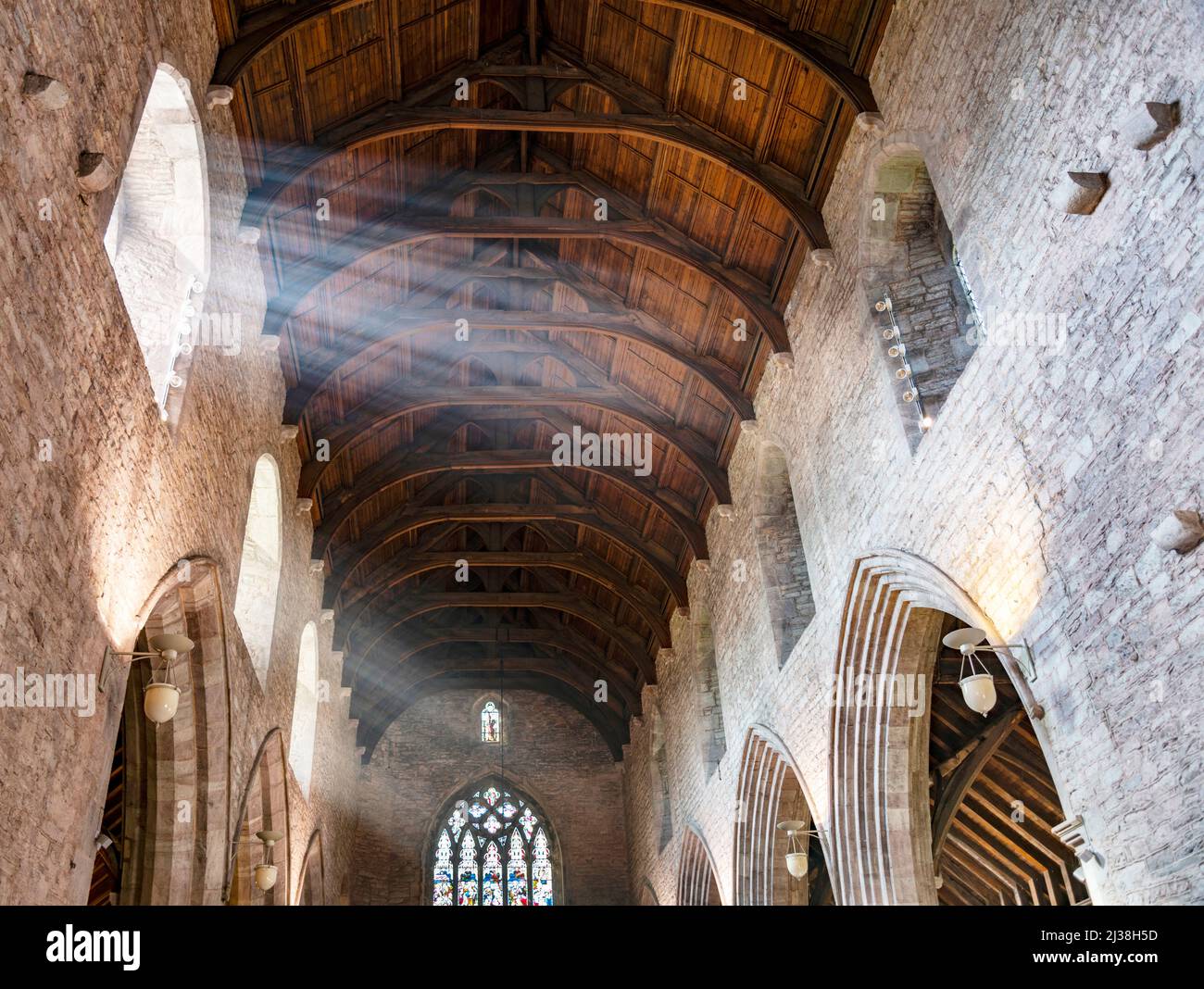 Beams of morning light pour through side windows,wooden rafters and ...