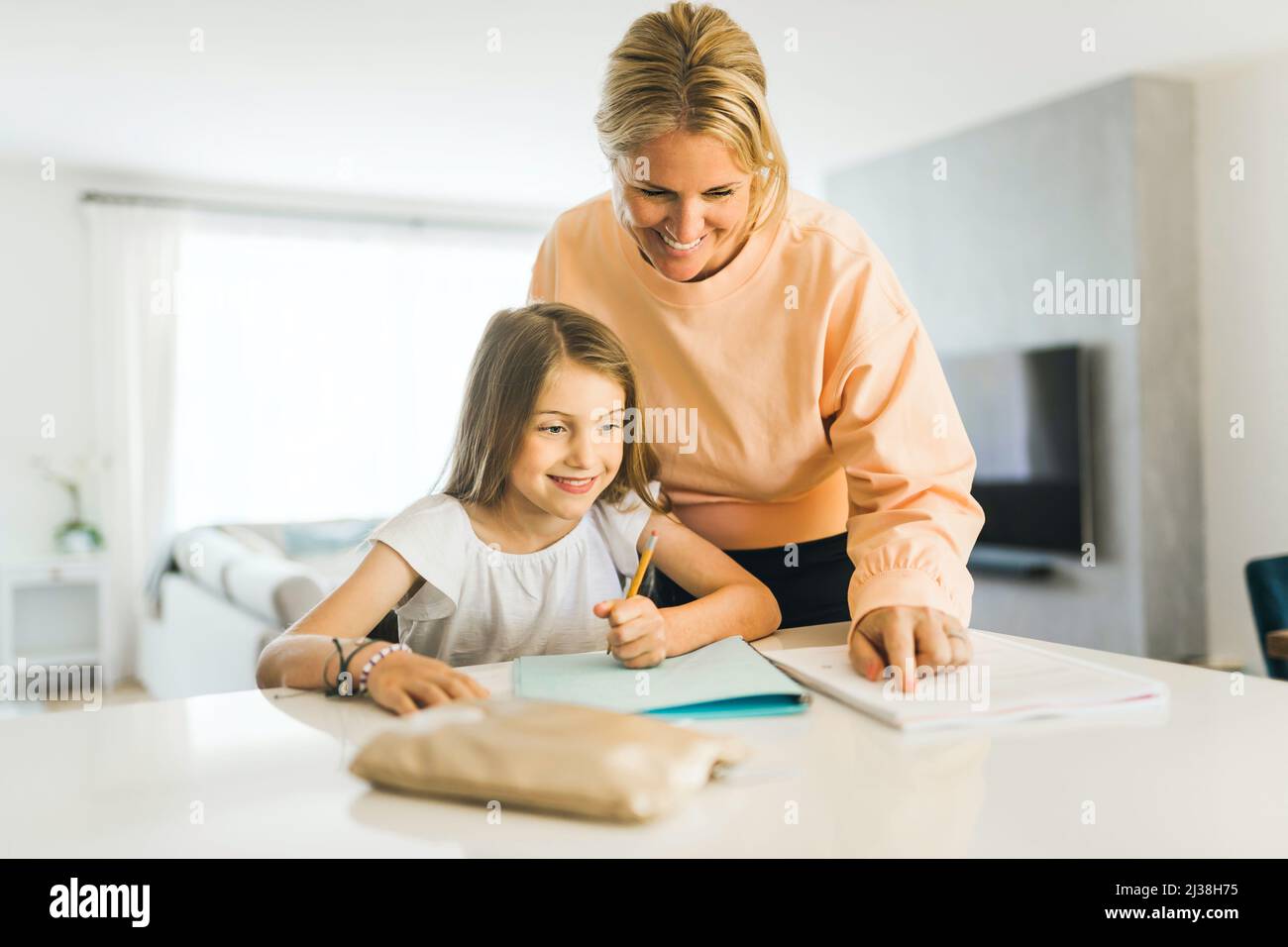Mom helping kid with homework at home Stock Photo - Alamy