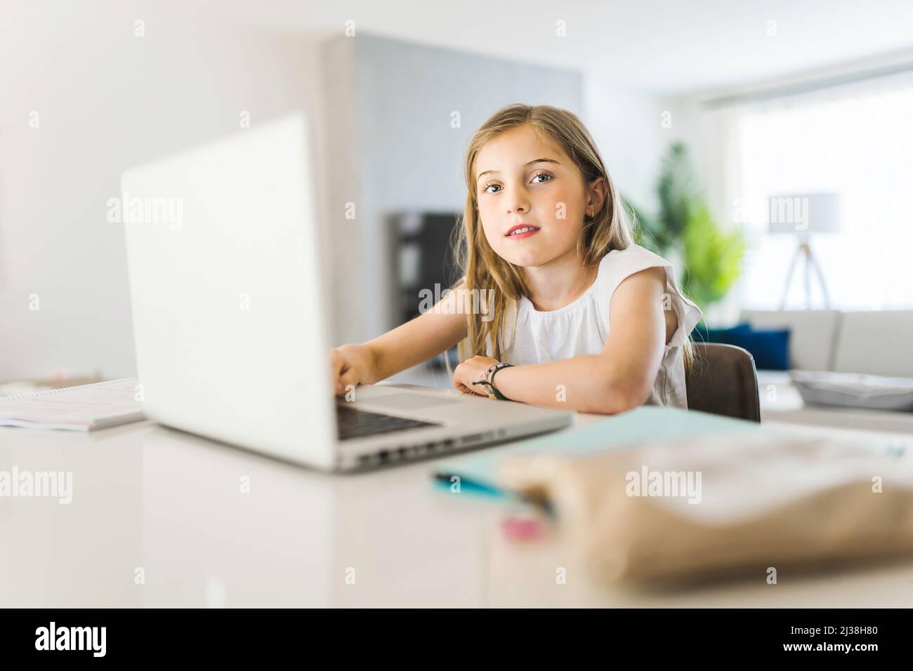 Pretty little girl enjoys learning and doing some homework Stock Photo ...