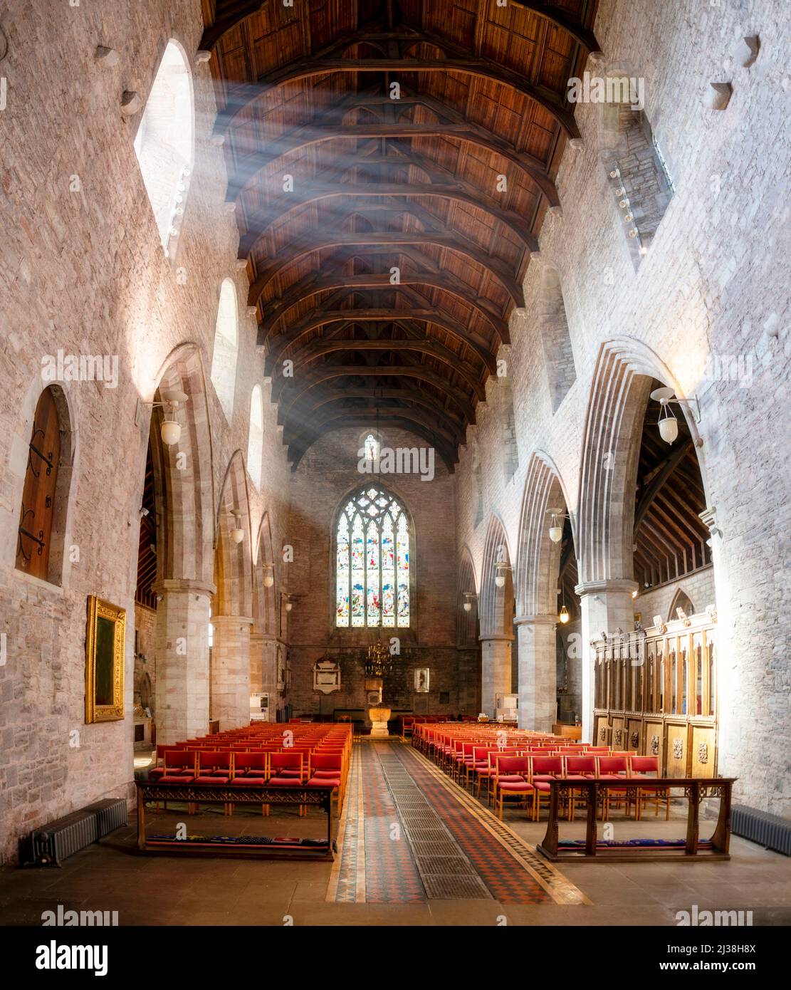 Beams of morning light pour through side windows,a carved wooden ...