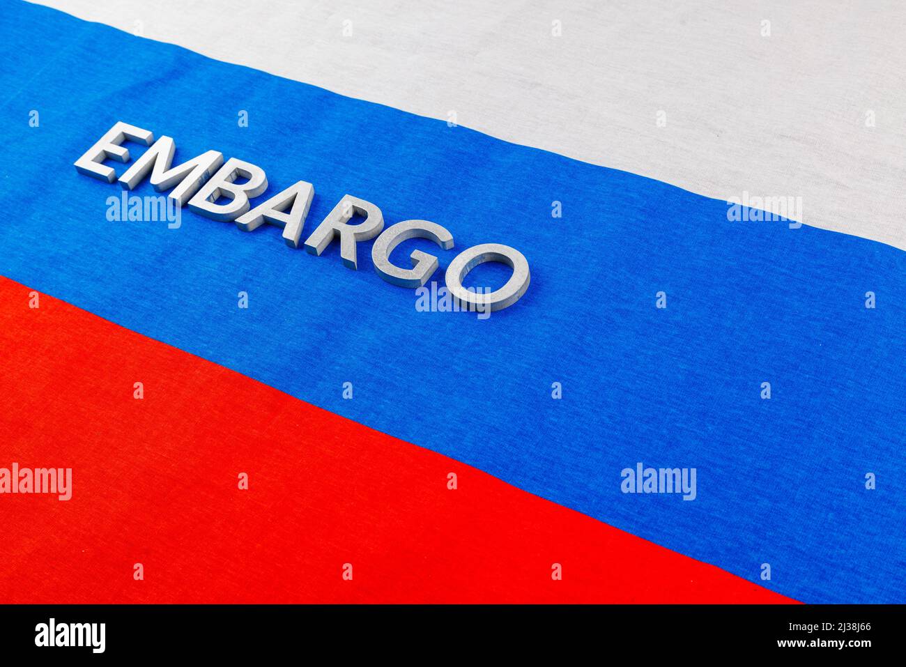 the word embargo laid with silver metal letters on russian tricolor ...