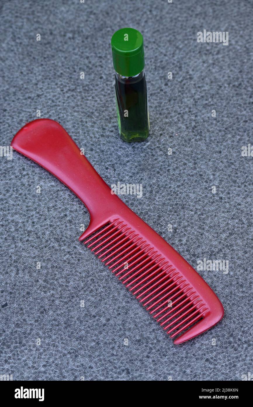 closeup the maroon color comb with green color gooseberry hair oil over ...