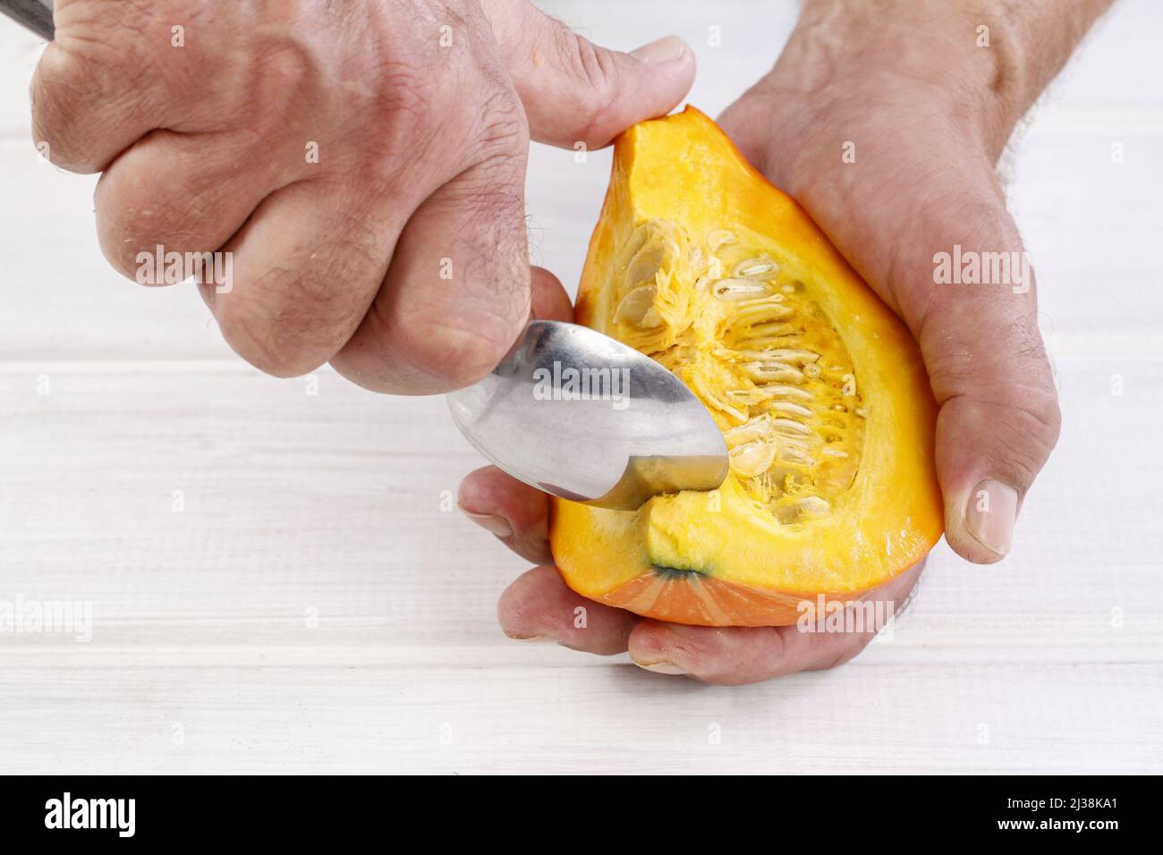 The cook shows how to remove pumpkin seeds with the spoon. Healthy food ...
