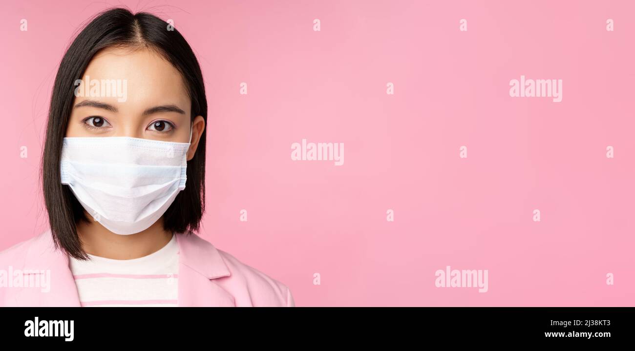Close up portrait of japanese businesswoman in medical face mask, suit ...