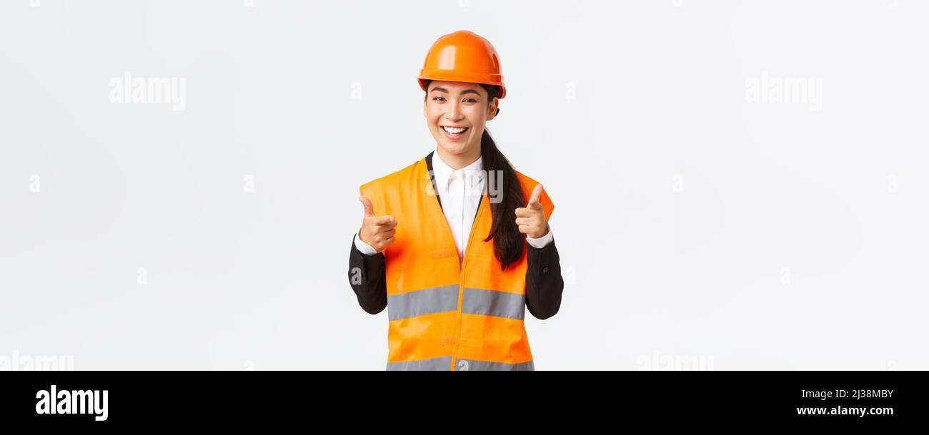 Confident pretty asian female construction manager in safety helmet and ...