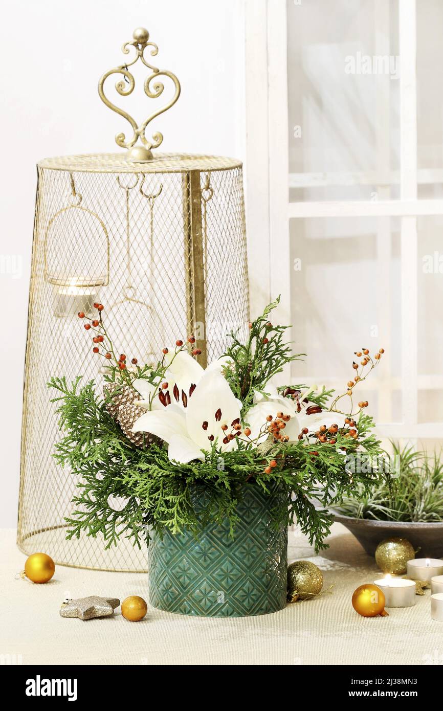 Christmas floral arrangement with white lilies, thuja twigs and golden ...