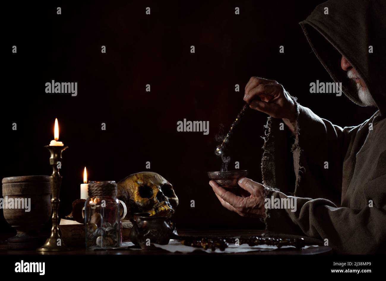 Medieval magician with magic wand mixing elixir Stock Photo - Alamy