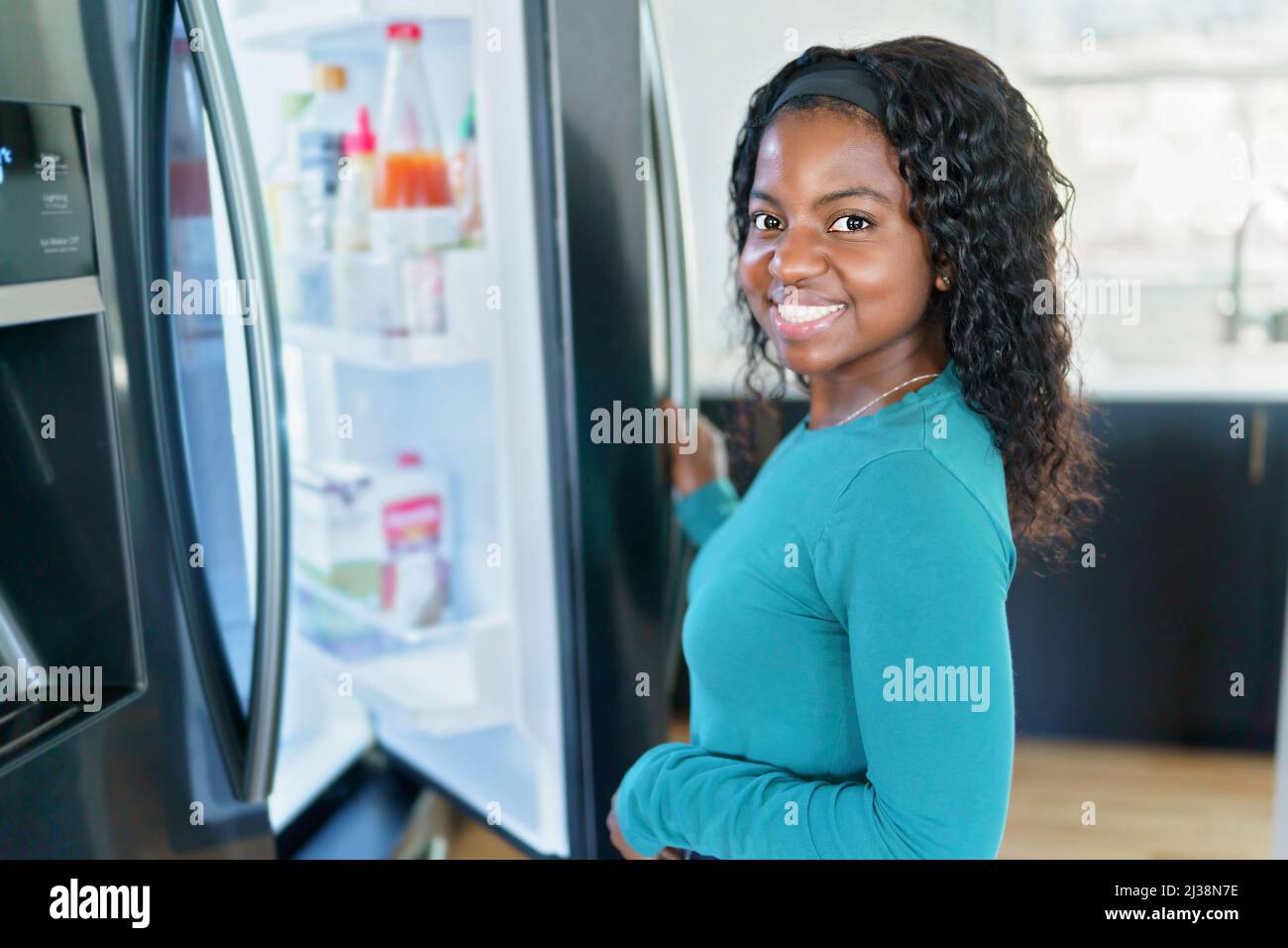 Young Woman on front of Fridge At Kitchen Stock Photo - Alamy